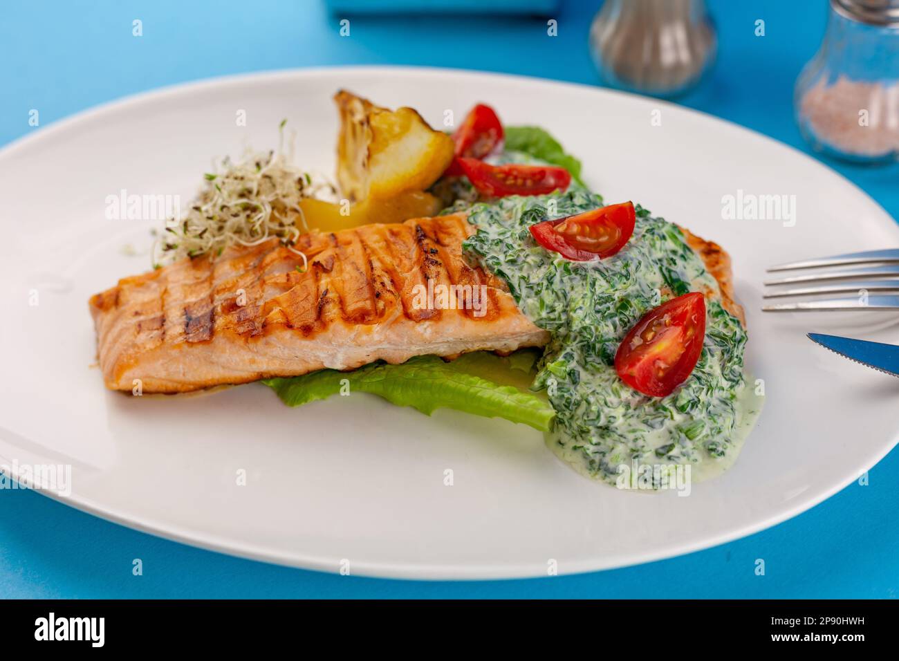 Grilled salmon steak. A piece of red fish on a white plate and a blue ...