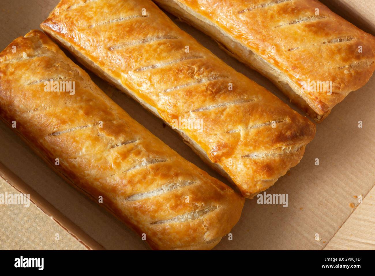 Sausage rolls in a cardboard takeaway tray. Sustainable biodegradable ...