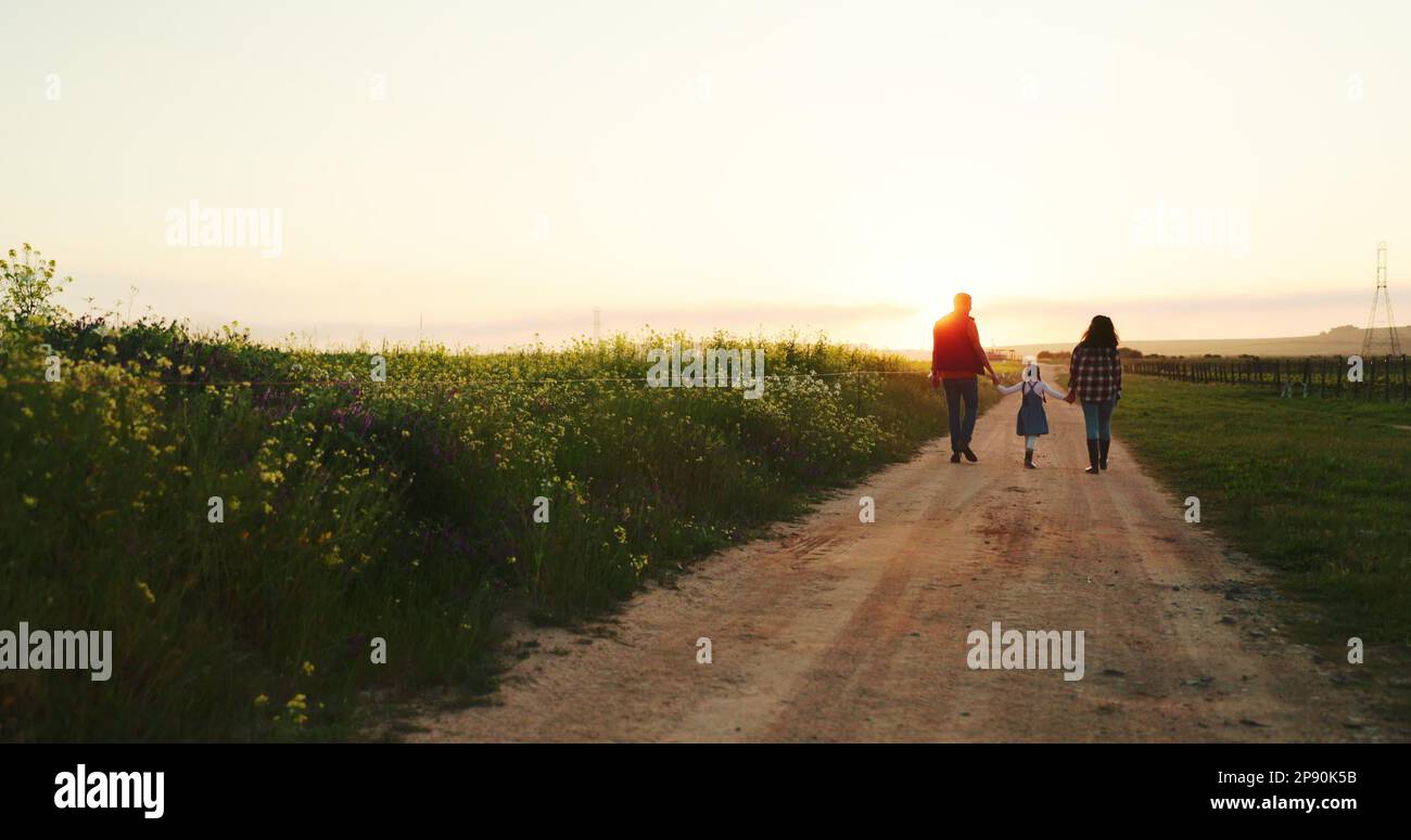 Man, woman or child holding hands on farm and sunset walking on nature ...