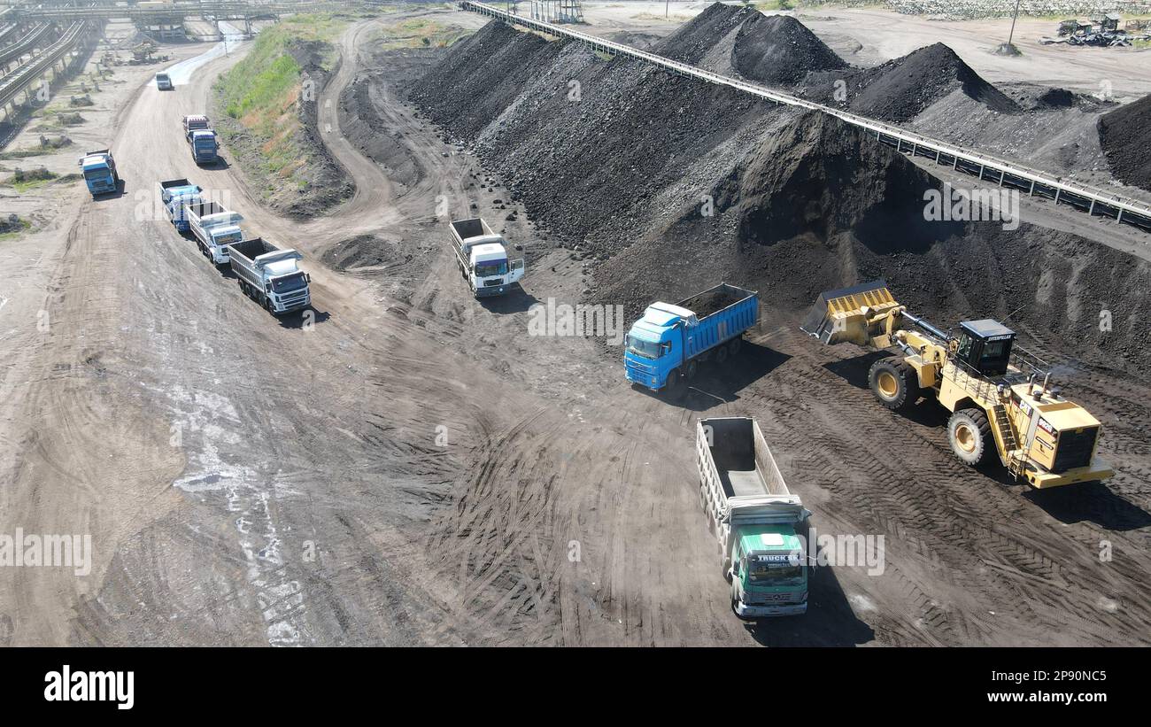 Wheel Loader loading coal on trucks, working at a huge mining site ...