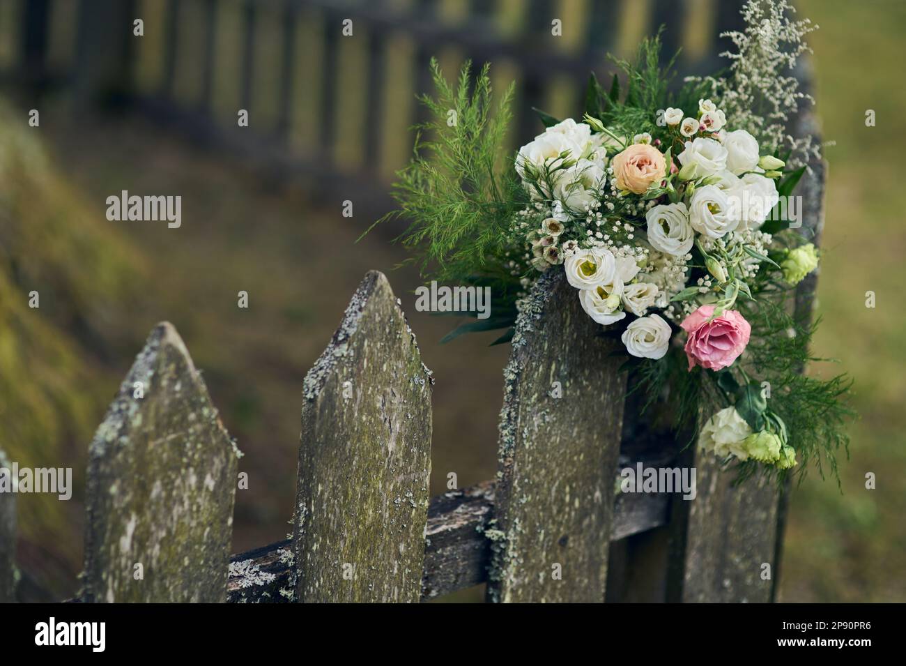 A bouquet of flowers on an old mossy fence Stock Photo - Alamy
