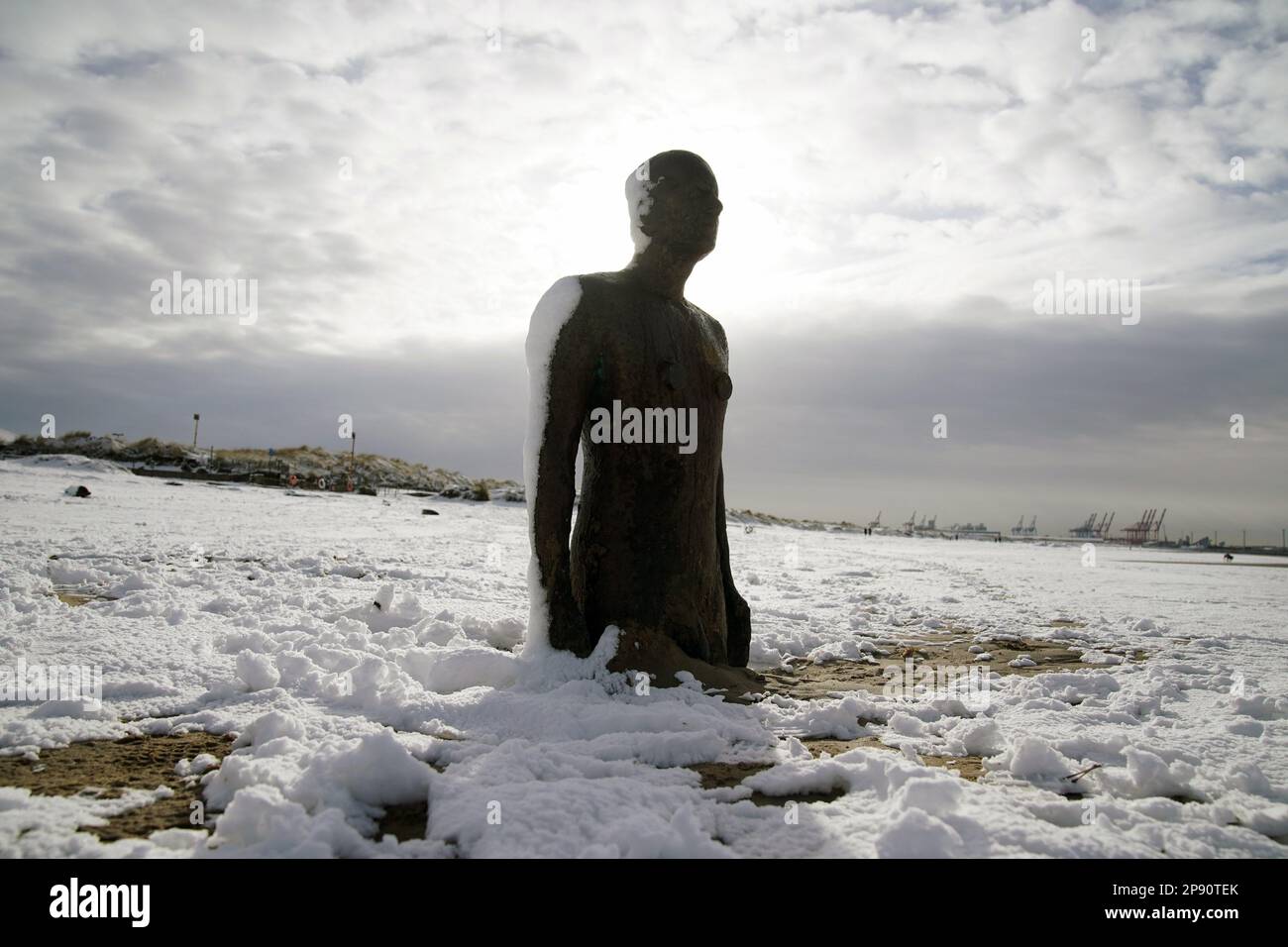Snow surrounds one of the Anthony Gormley statues called Another Place ...