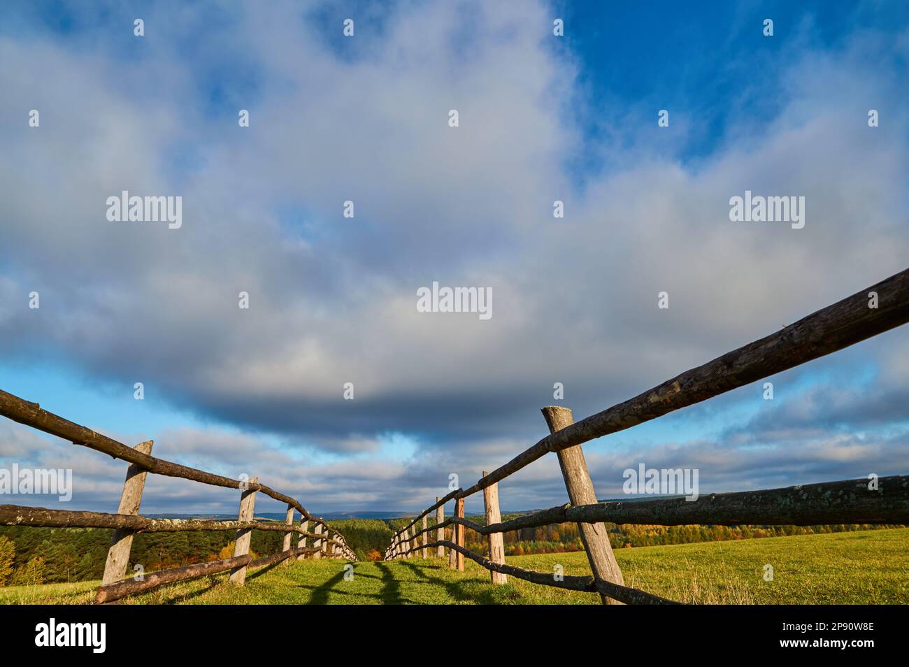 The road to the top of the mountain is fenced with wooden handrails ...