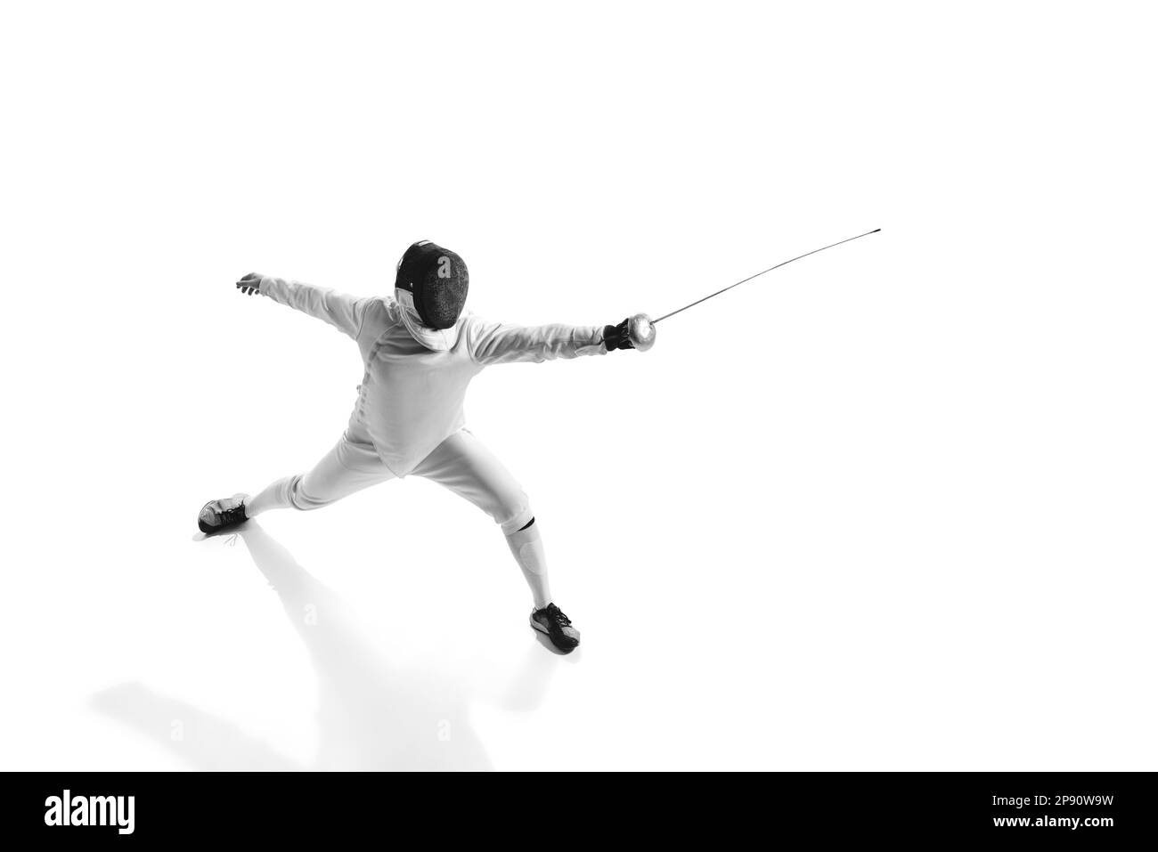 Dynamic portrait of male athlete in fencing costume with sword in hand ...