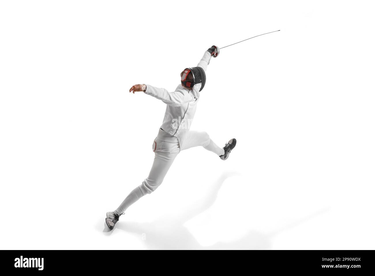 Dynamic portrait of male athlete in fencing costume with sword in hand ...