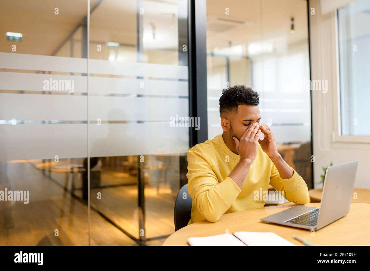 Overworked from work frustrated indian guy sitting at the desk, looking ...