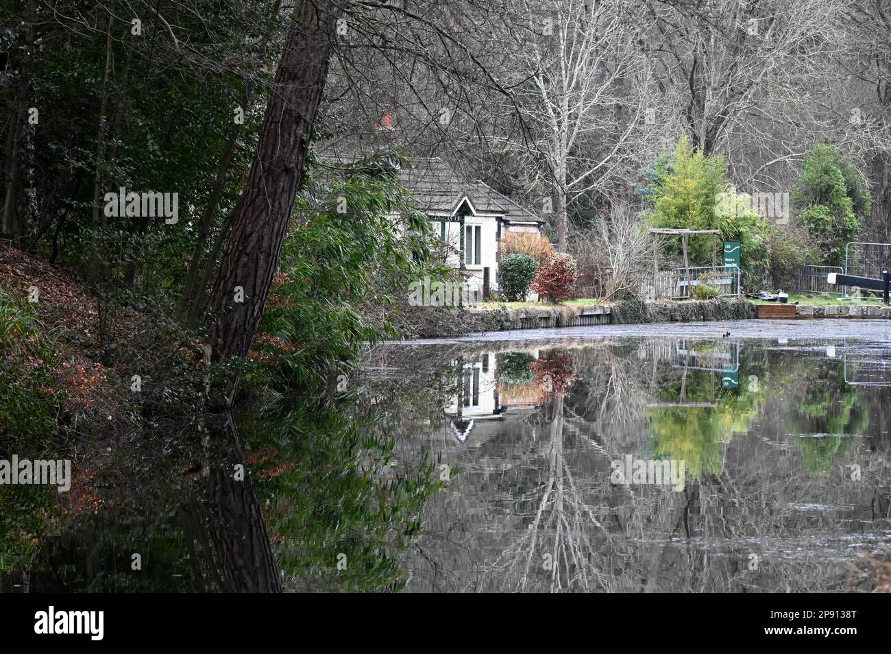 An old canal cottage reflected in the waters of the beautiful ...