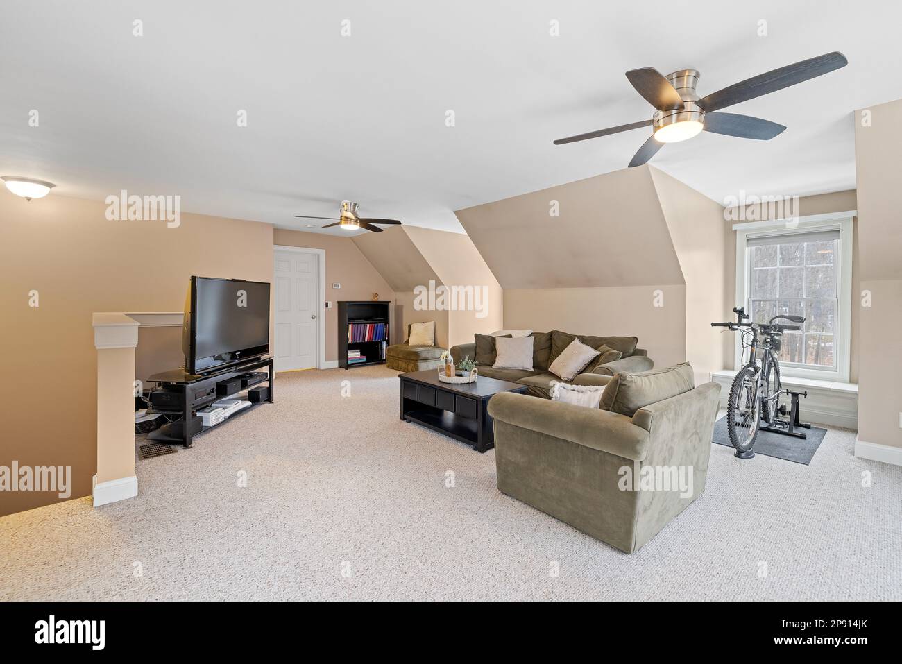 The living room features beige walls and carpeted floors, creating a ...