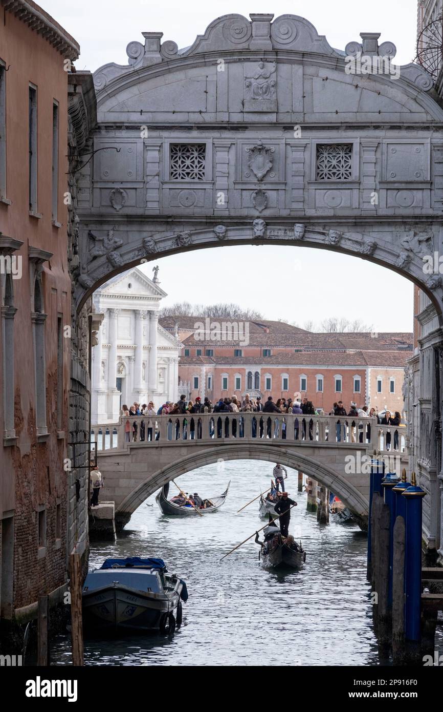 Gondoliers paddle their gondolas under the Ponte dei Sospiri (Bridge of ...