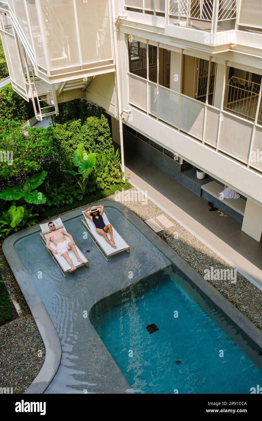 couple of men and women at a swimming pool at an art deco luxury hotel ...