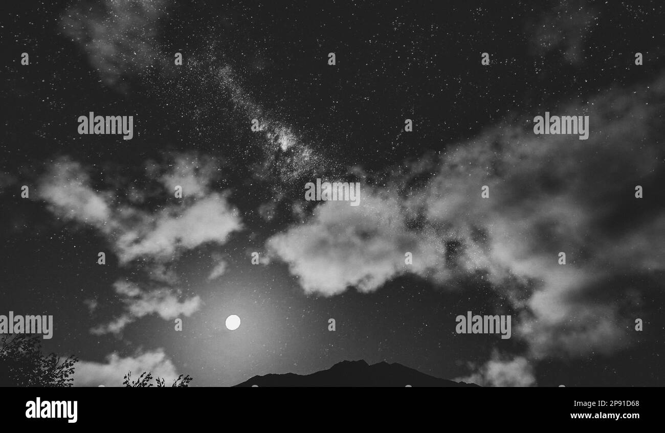 A stunning night sky featuring clouds and stars illuminated against ...