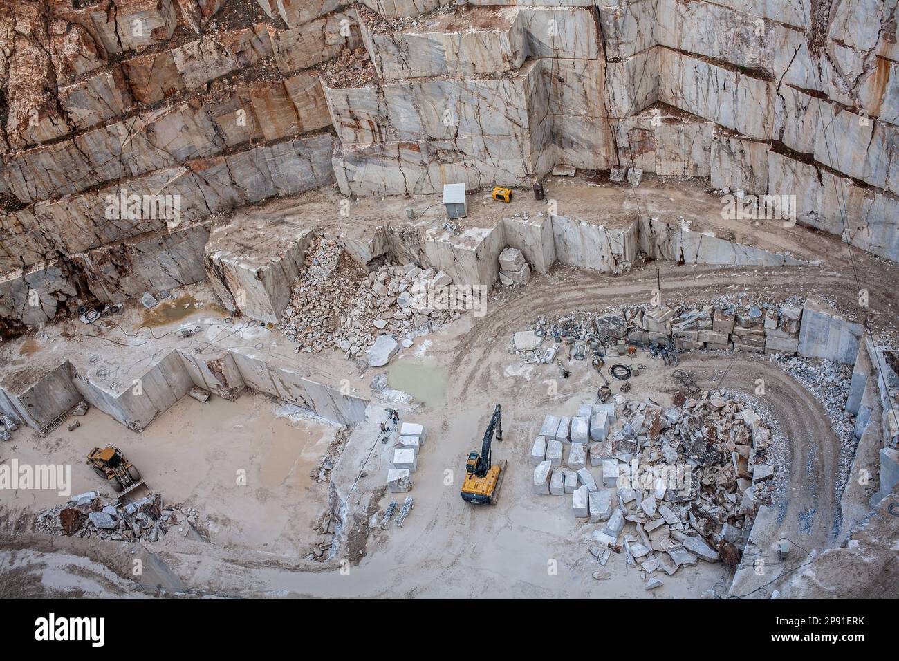 Workers and construction equipment continue to work in the deep pit. The quarries at Iscehisar ...