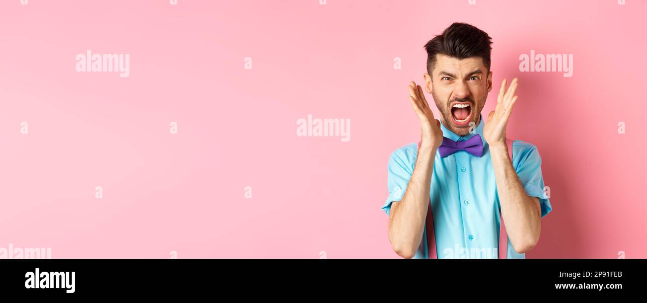 Angry man screaming like crazy, shaking hands and stare furious at ...