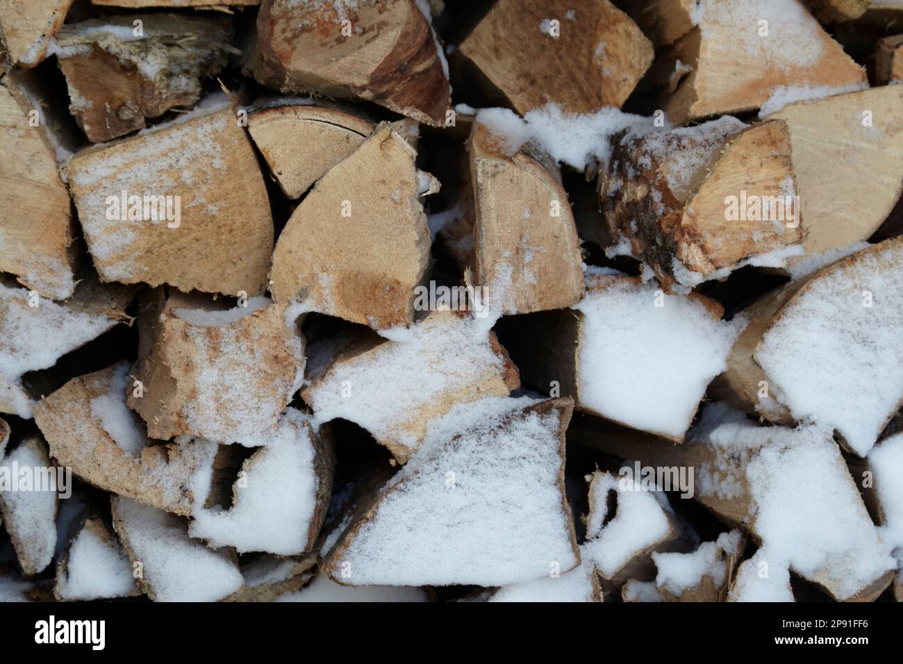 snow coating hard wood log store after heavy snowfall in winter ...