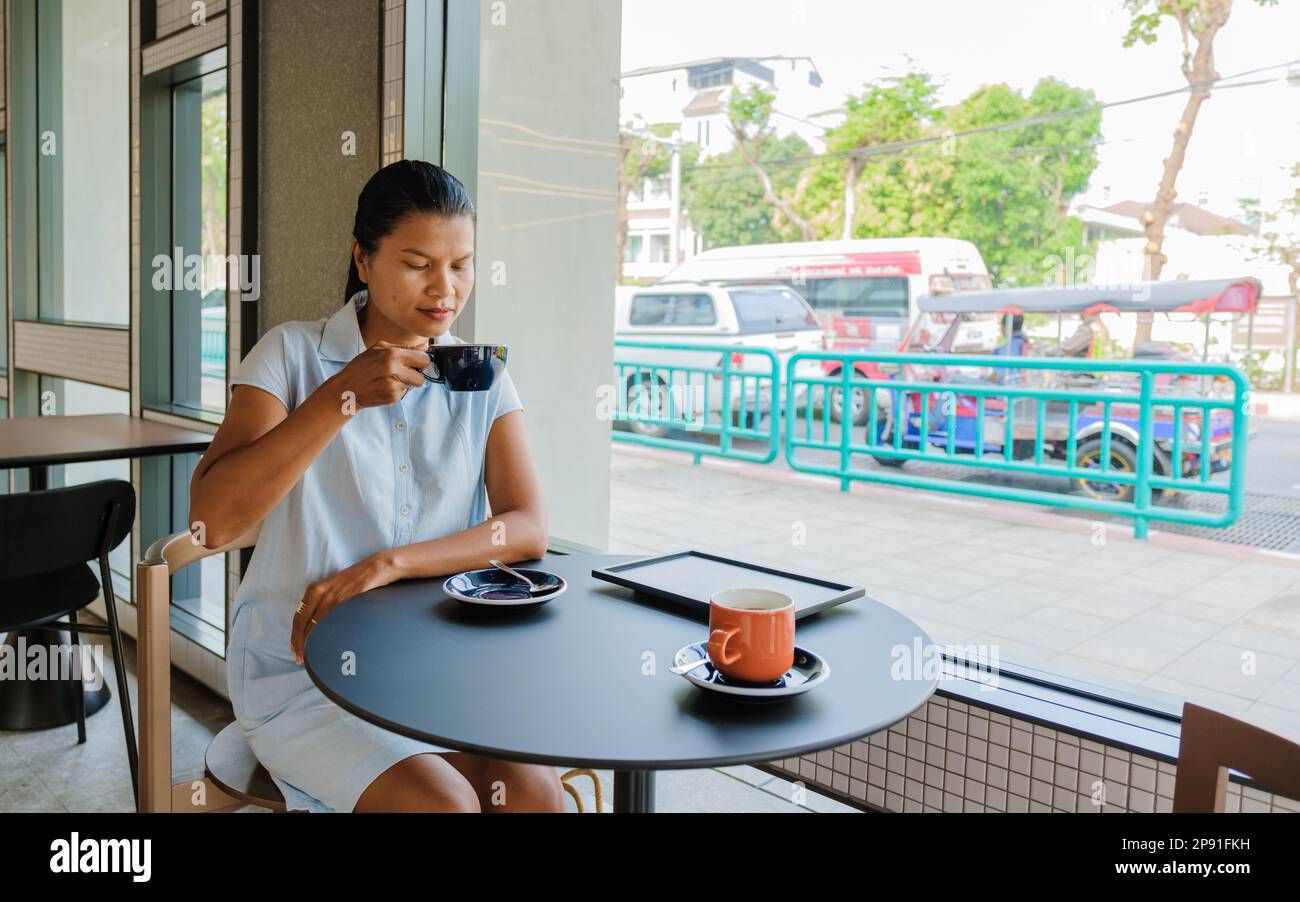 Asian women drinking coffee in a cafe in Bangkok Thailand with a look ...