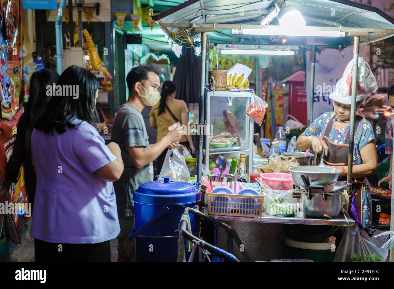 Bangkok Ratchawat Thailand people prepare Thai street food at a food stall with a wok pan stir ...