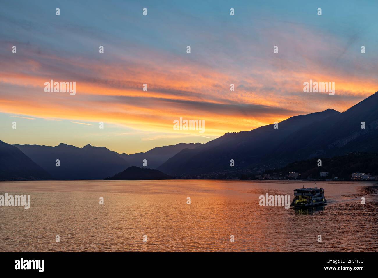 dramatic sunset over lake como with ferry boat approaching bellagio ...