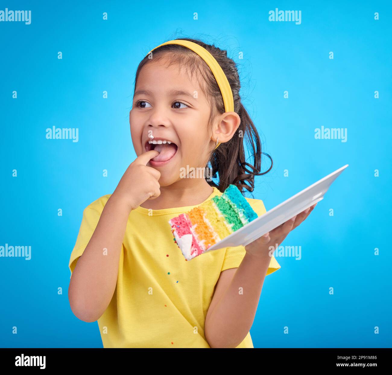 Happy, tasting and girl with cake, excited and cheerful against blue ...