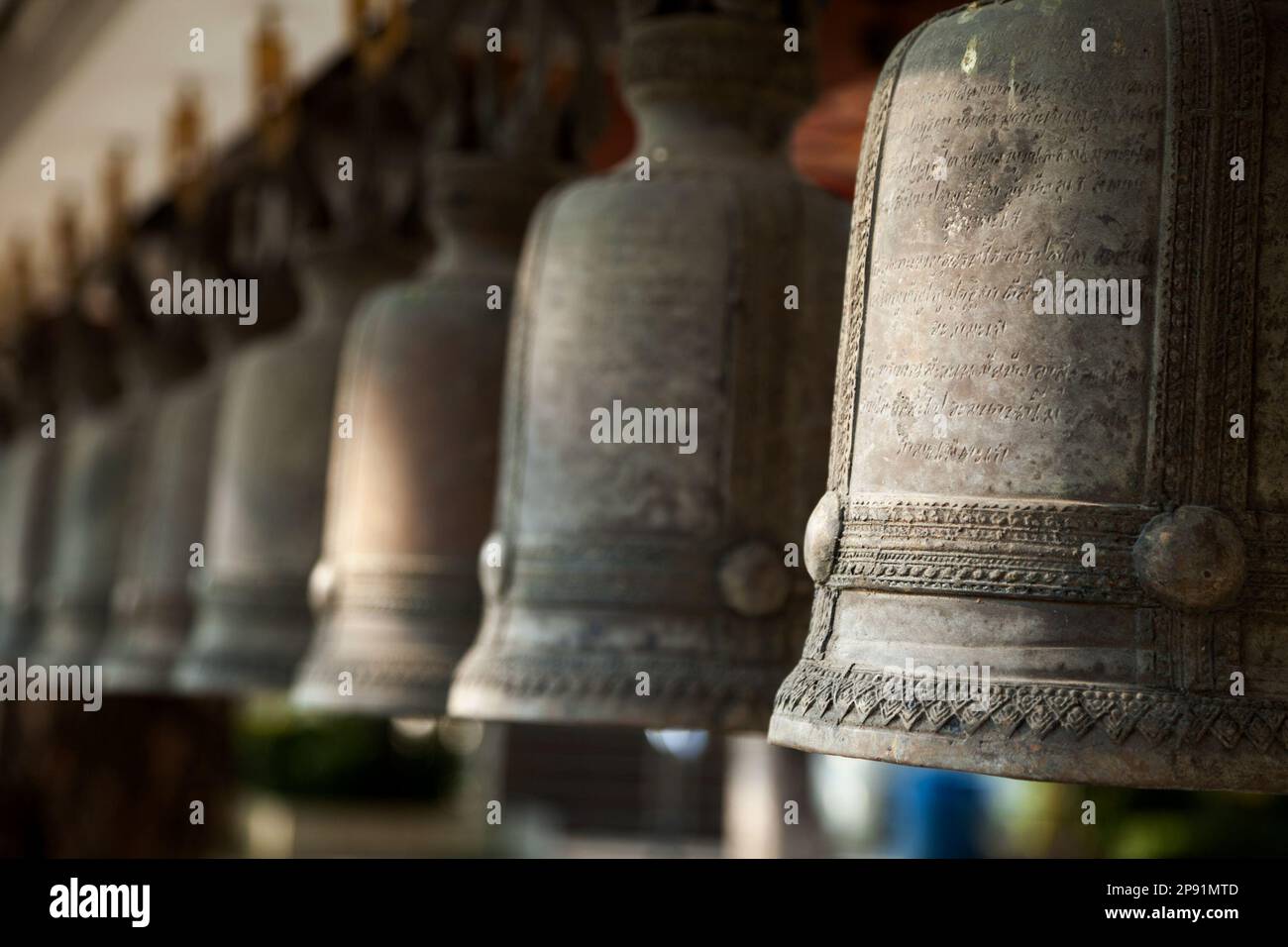 Row of religious bells in a Buddhist shrine. Asian monastery bronze ...