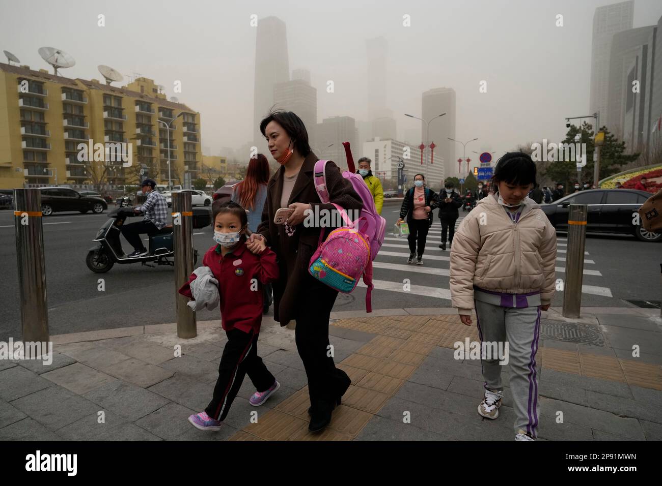Residents walk on the street as a dust storm sweep by in Beijing ...