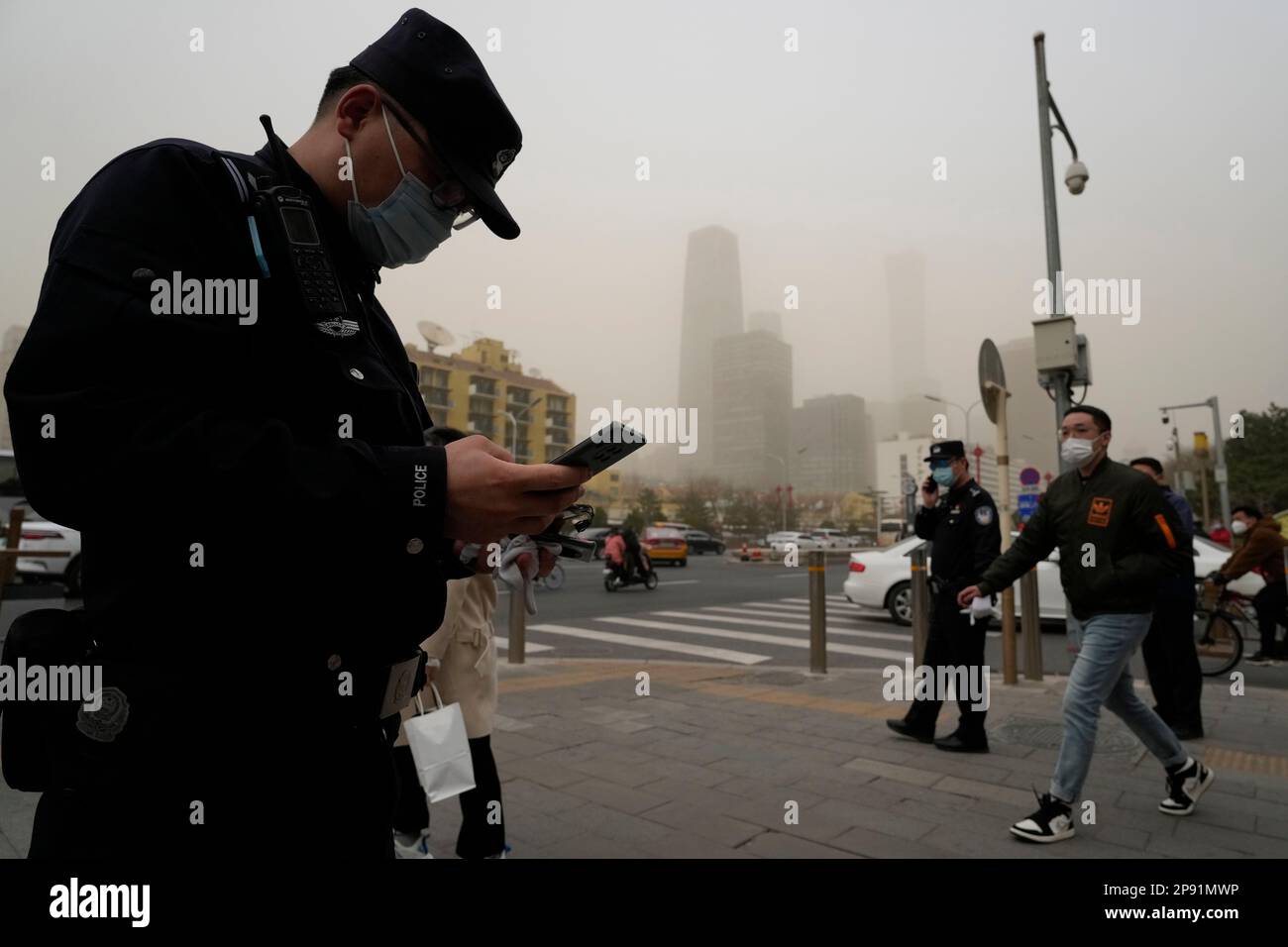 Chinese police officers monitor a junction as a dust storm sweep by in ...