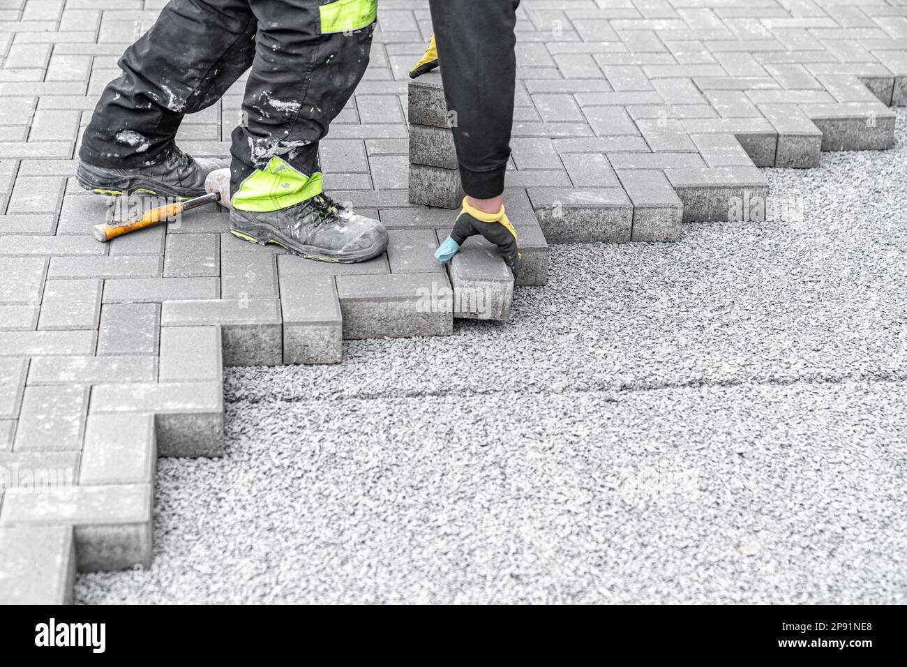 laying interlocking pavers during the construction of sidewalks and ...