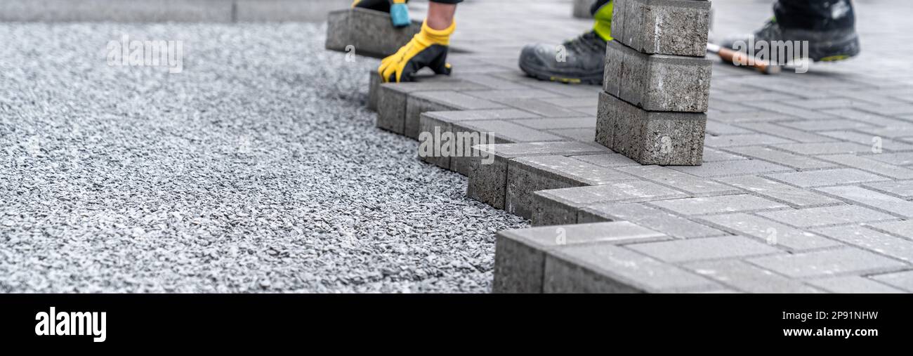 laying interlocking pavers during the construction of sidewalks and ...