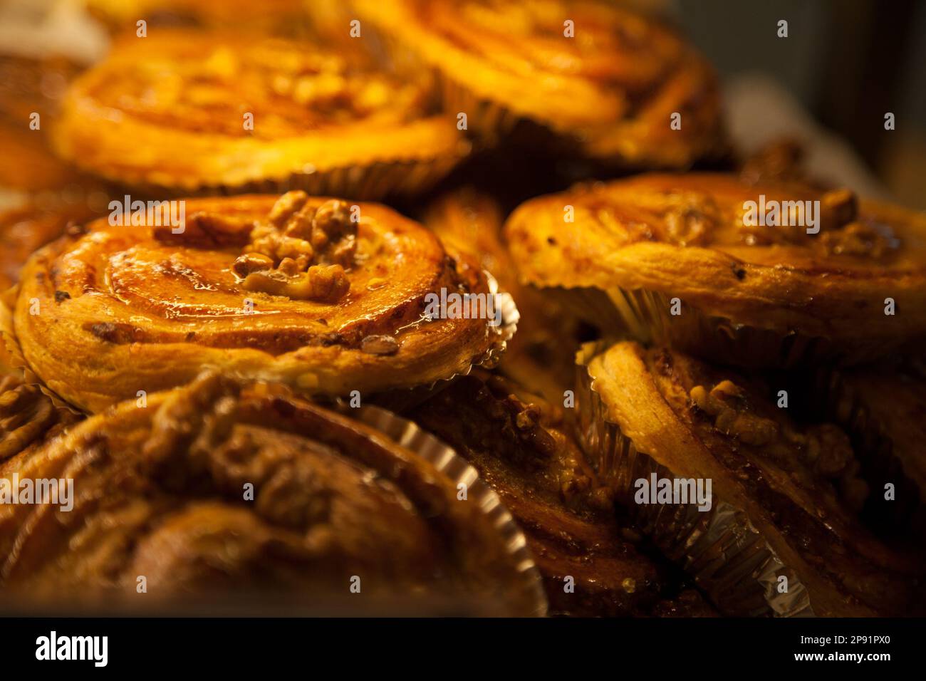 Many tarts with walnuts pastry shop display. Lots of bakery yellow ...
