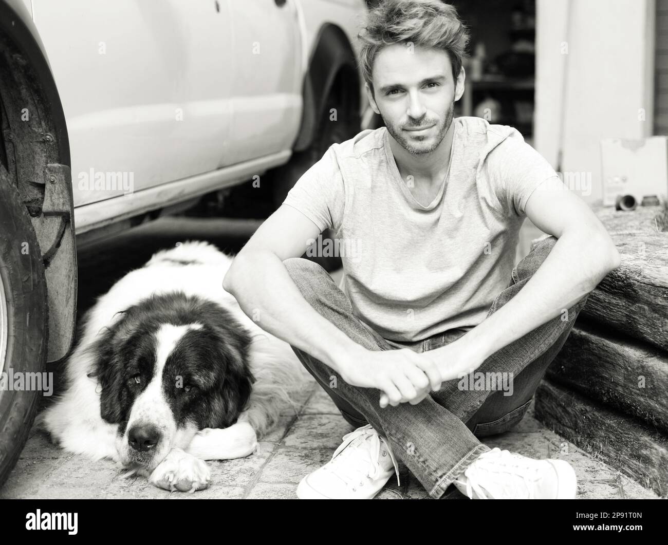 Cute portrait of a handsome adult chilling outdoors next to his dog, a ...
