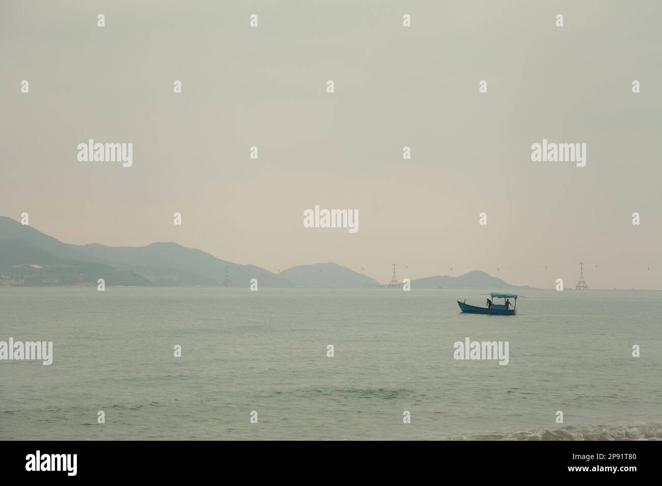 Misty gray seascape with a Vietnamese fishing boat. Fishermen in the ...