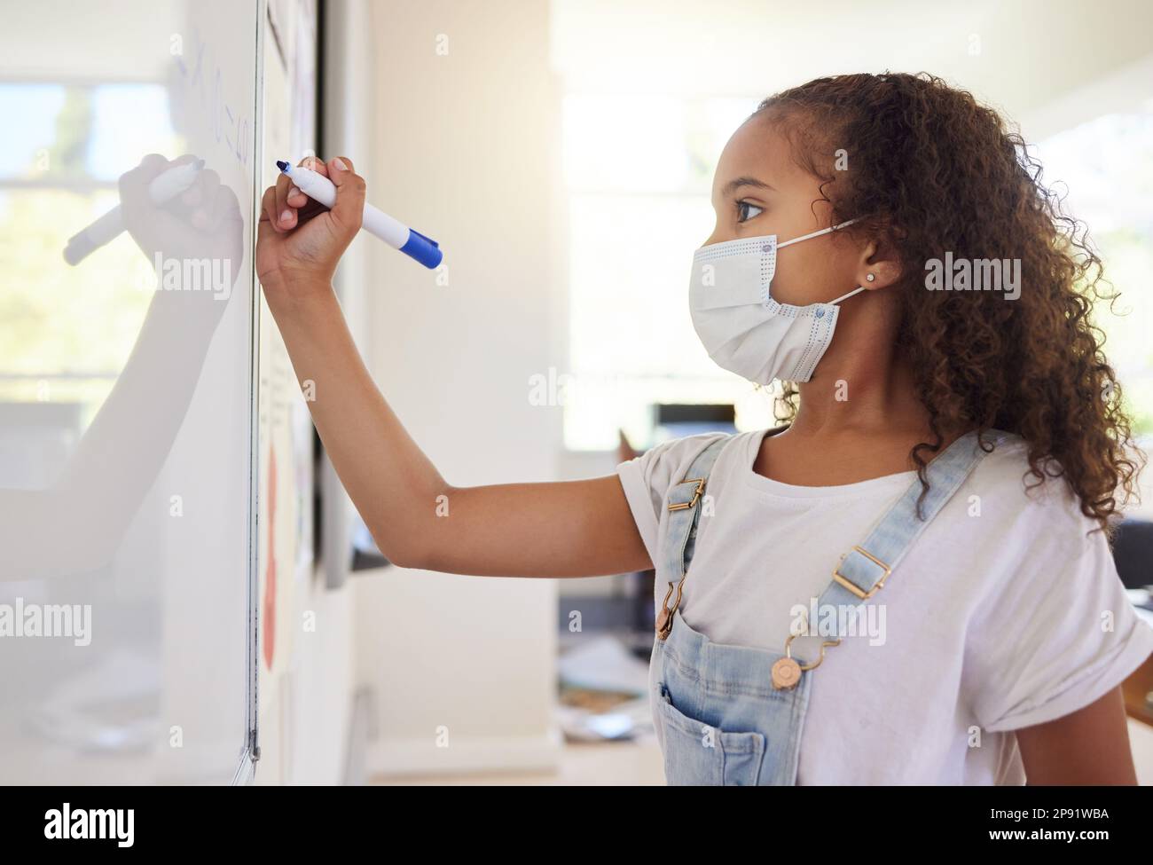 Smart, clever and intelligent girl writing an answer on a whiteboard at ...
