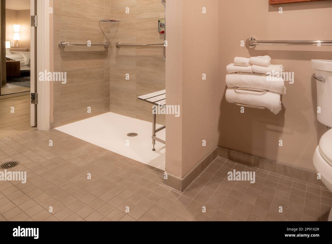 Wheelchair accessible hotel bathroom shower with tile floor and walls ...