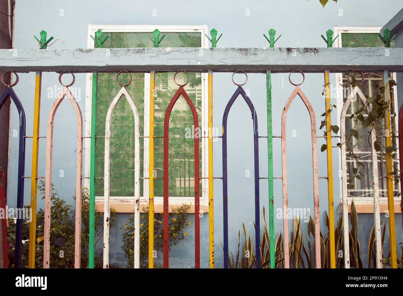 Colorful decorative metal fence around a house. Pastel colors ...