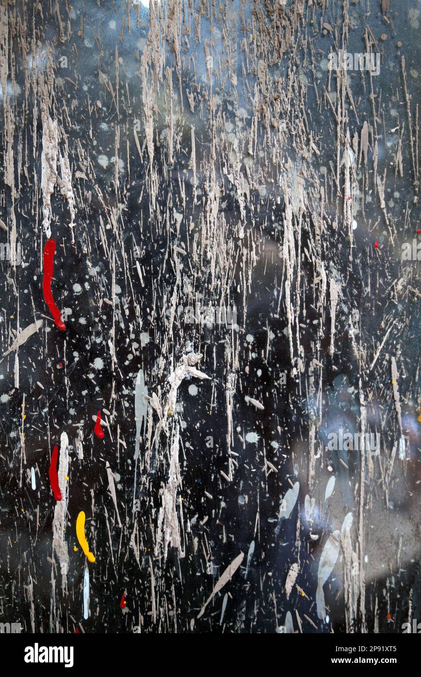 Abstract paint splash on a gray wall. Red and yellow stains on a messy ...