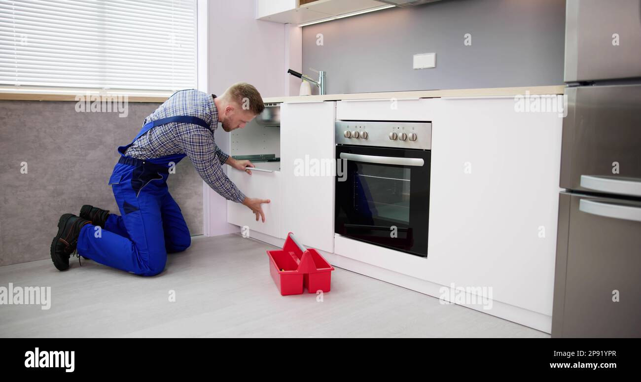 Carpenter Installing And Assembling Kitchen Furniture. Maintenance ...