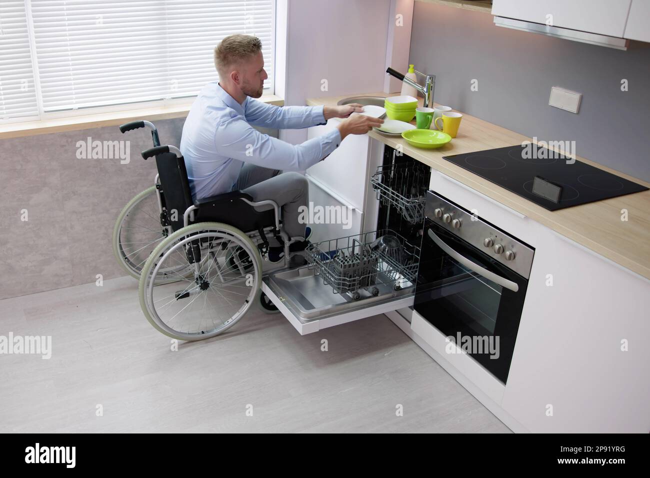Person With Disability In Wheelchair Using Dishwasher In Kitchen Stock ...