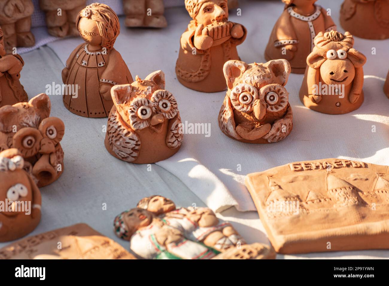Clay figurines of animals, clay handmade owl in the rays of the autumn ...
