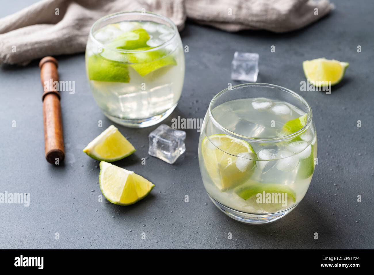 Brazilian lemon caipirinha in glasses with ice and fruit slices over ...