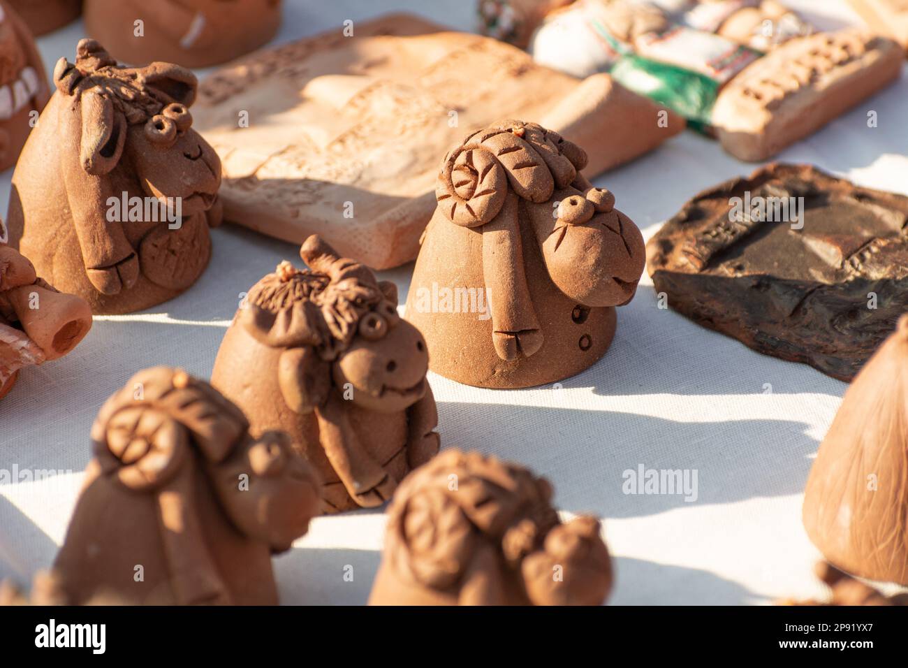 Clay figurines of animals, clay handmade sheep in the rays of the ...