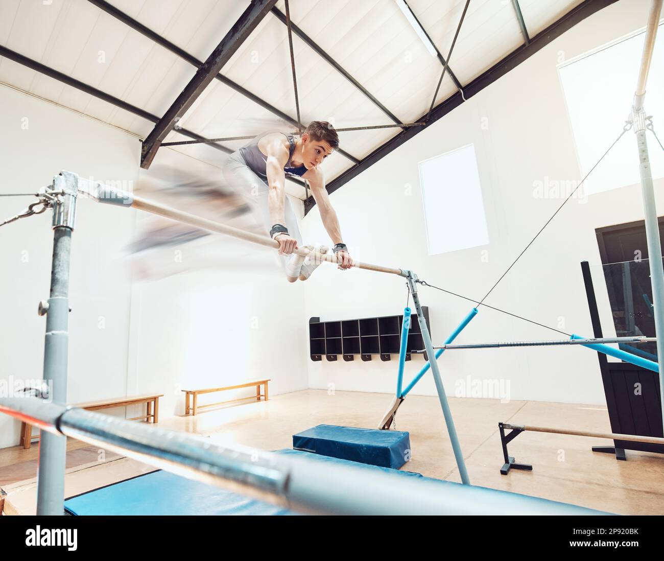 Gymnastics, olympics and sports with a gymnast swinging on a horizontal ...