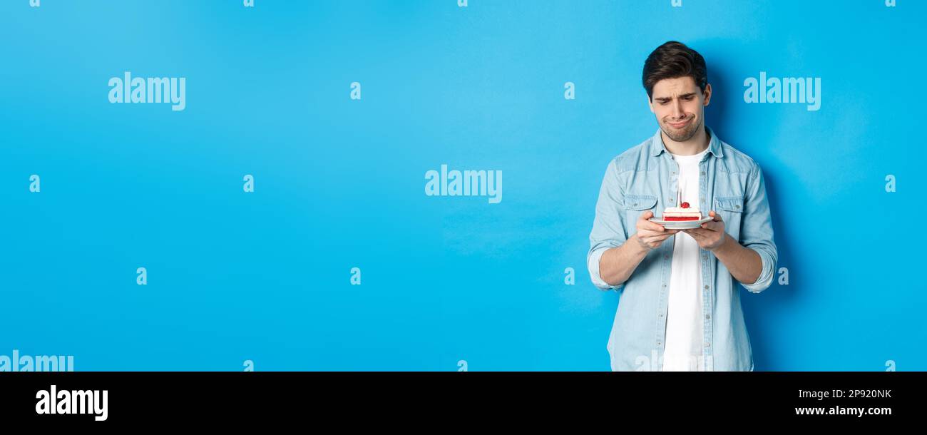 Holidays and celebration. Disappointed and sad man looking at birthday ...