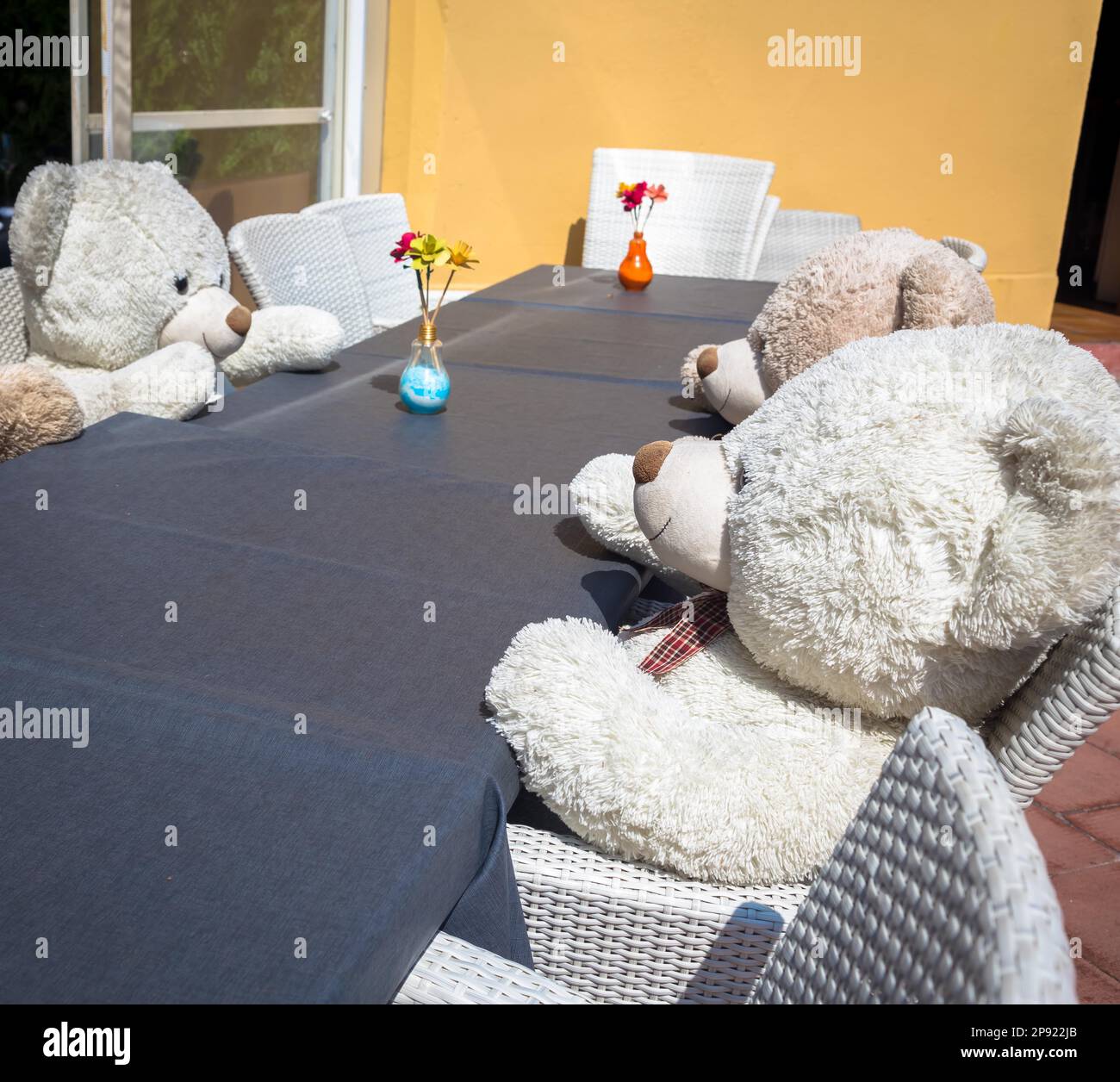 A group of Teddy Bears sitting at the a table and ready for a lunch or ...