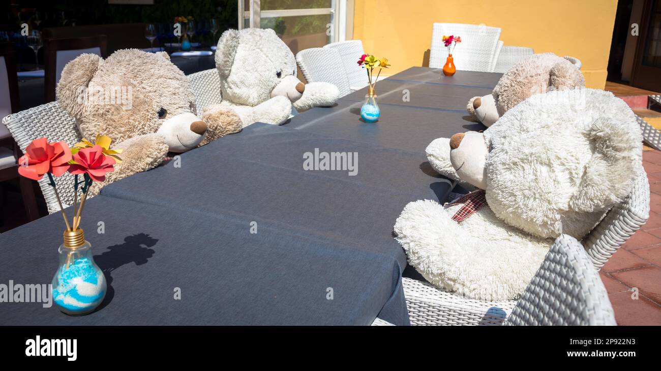 A group of Teddy Bears sitting at the a table and ready for a lunch or ...