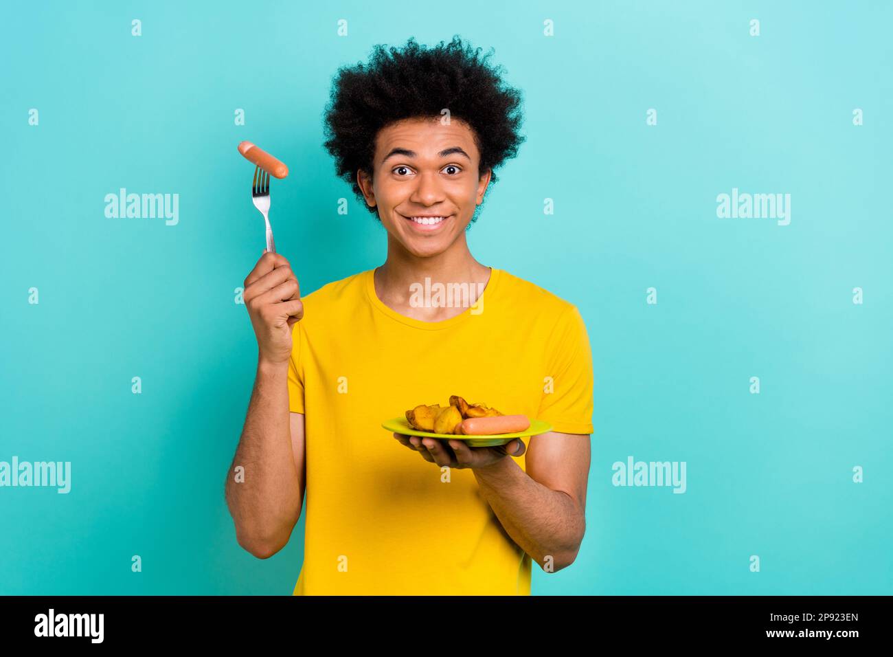 Portrait of funky positive man hold fork eat sausage potato plate ...