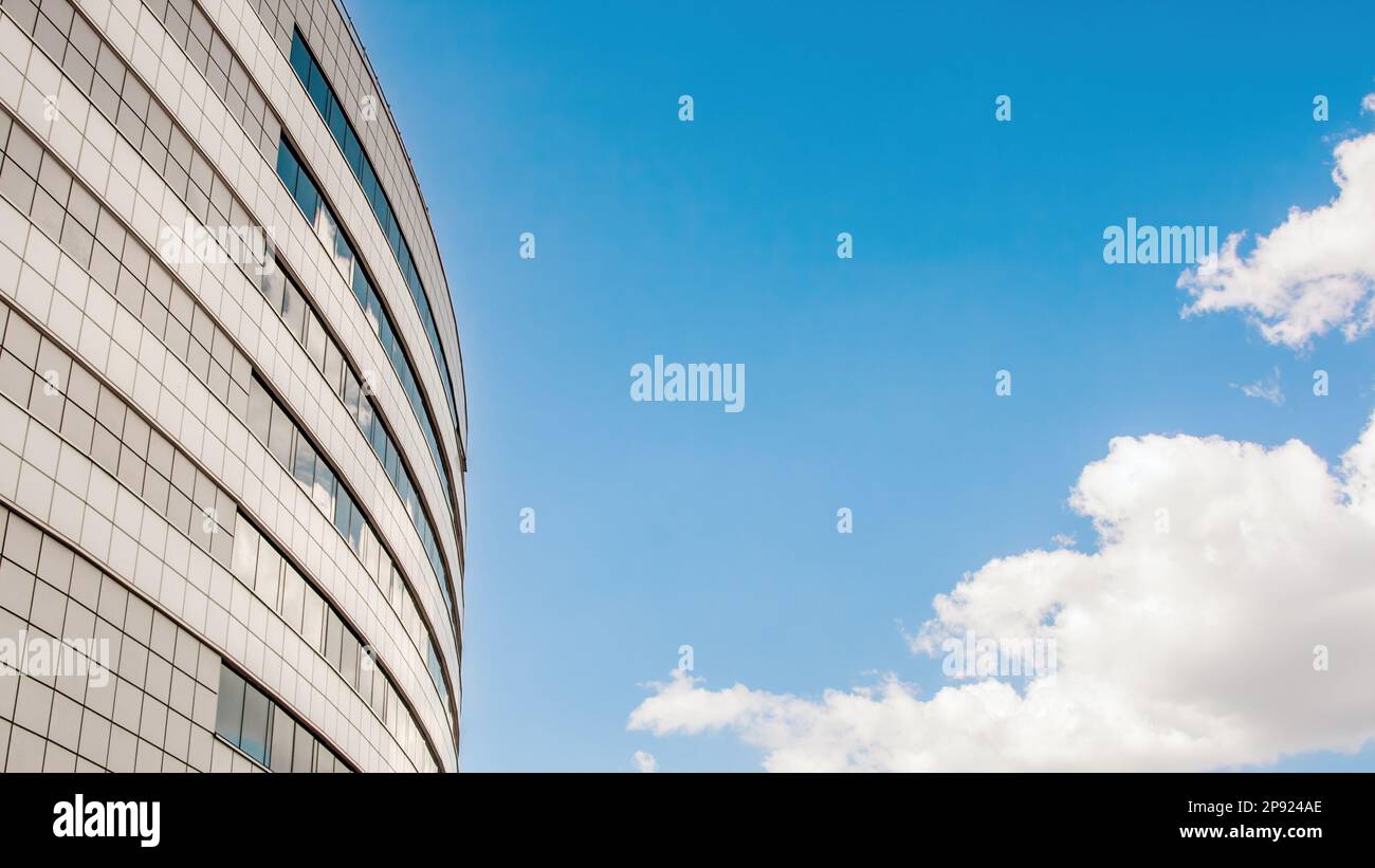 Facade of a modern building at an angle against a bright sky ...