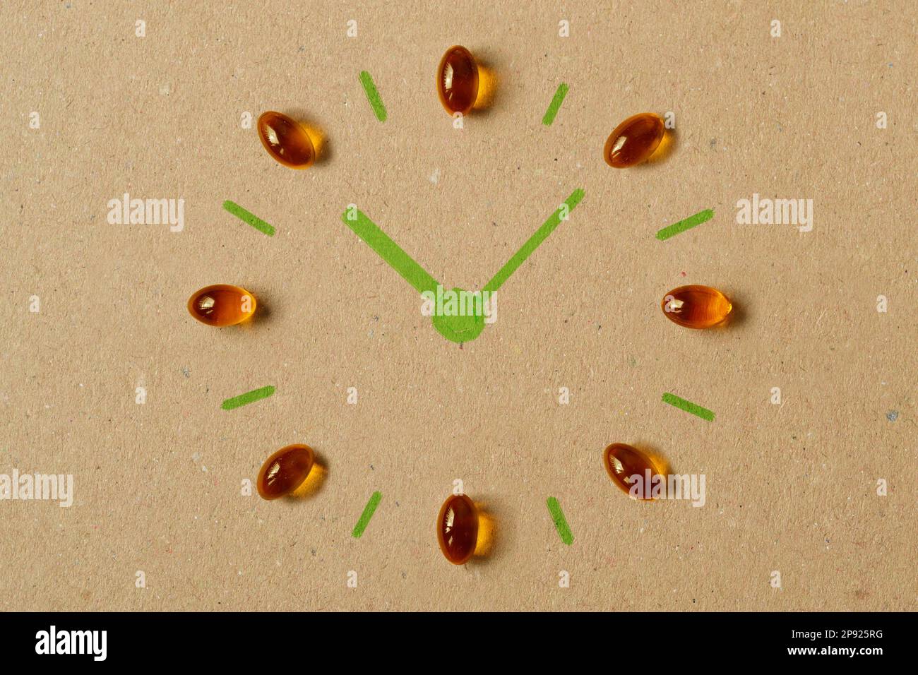 Clock made of omega 3 Fish Oil capsules on recycled paper background ...