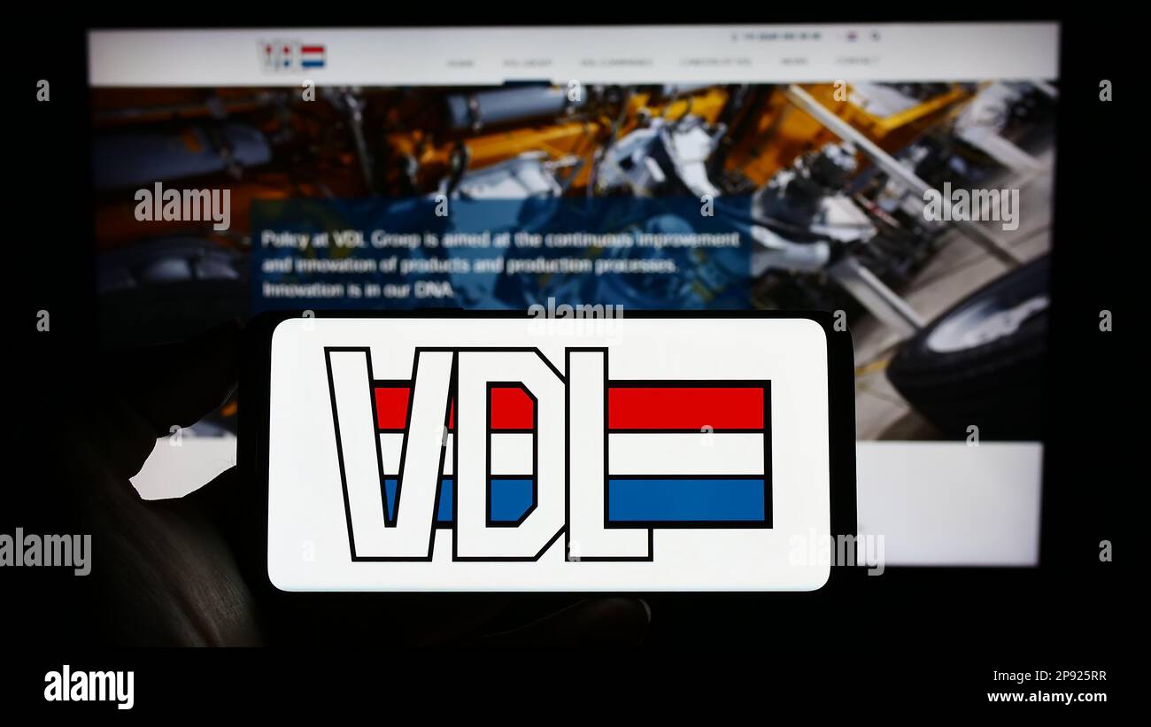 Person holding mobile phone with logo of Dutch manufacturing company ...