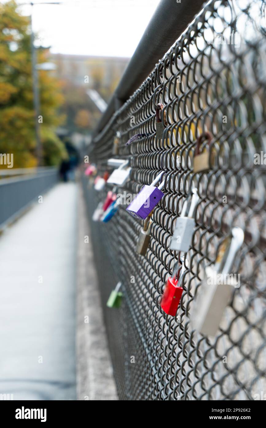 Many different color and style locks and the wire railing of a bridge ...