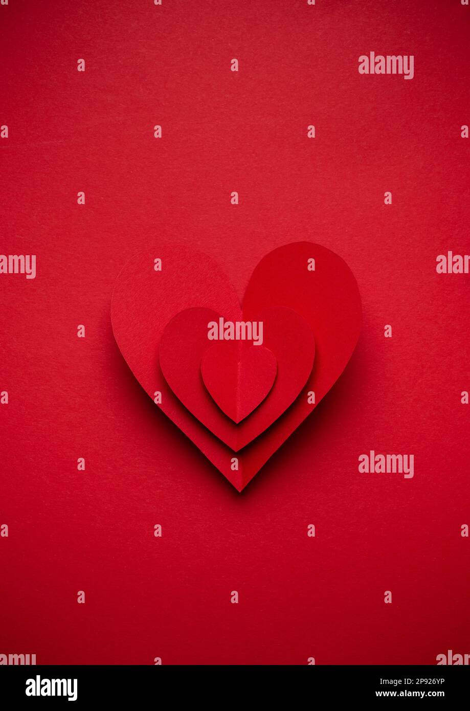 Big voluminous red heart cut from paper on red monochrome background ...