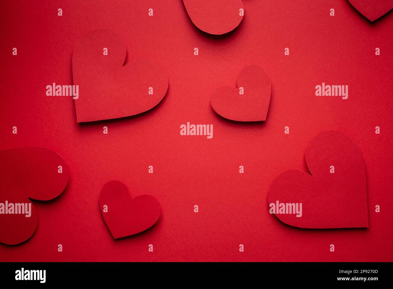 Red hearts cut from paper on red background, paper craft origami style ...